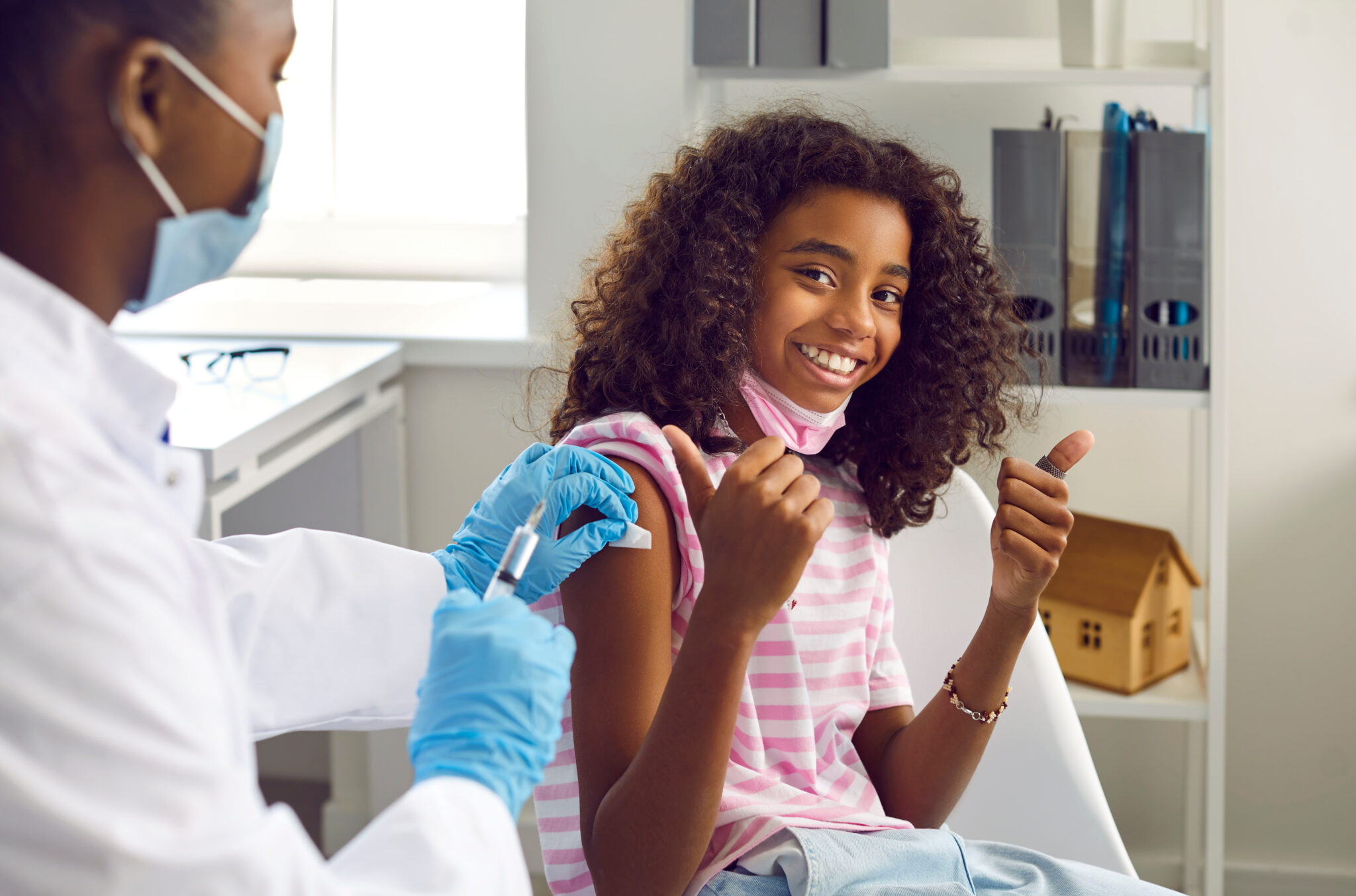 Happy African American child receives vaccine injection, smiles and ...